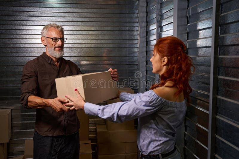 Spouses Loading Cardboard Boxes with Things into a Storage Container ...