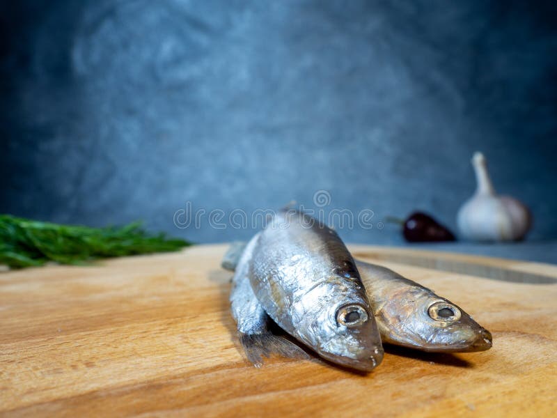 Sprat on a Cutting Board. Whole Fish, Pepper, Dill and Garlic on the ...
