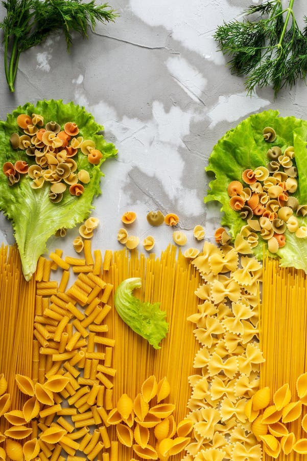 Spread Out on a Concrete Background Different Pasta and Greens Stock ...