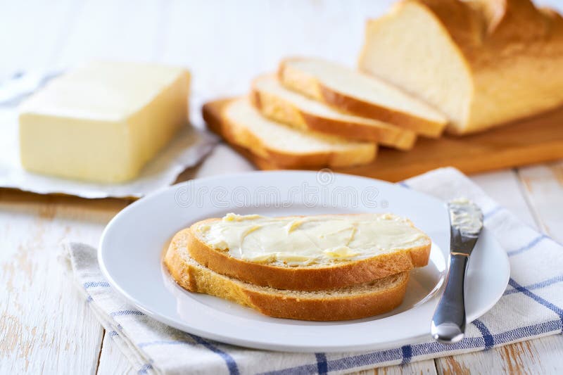 Spreading Butter in To White Wheat Bread Slices on a Light Kitchen ...