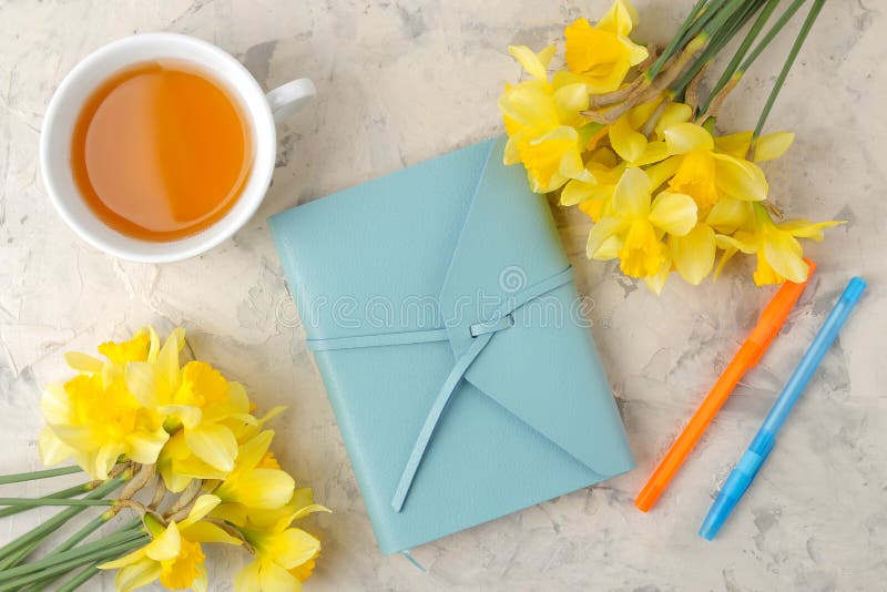 Spring Flowers, Yellow Daffodils and a Cup of Tea, a Notebook on a Light Concrete Background ...