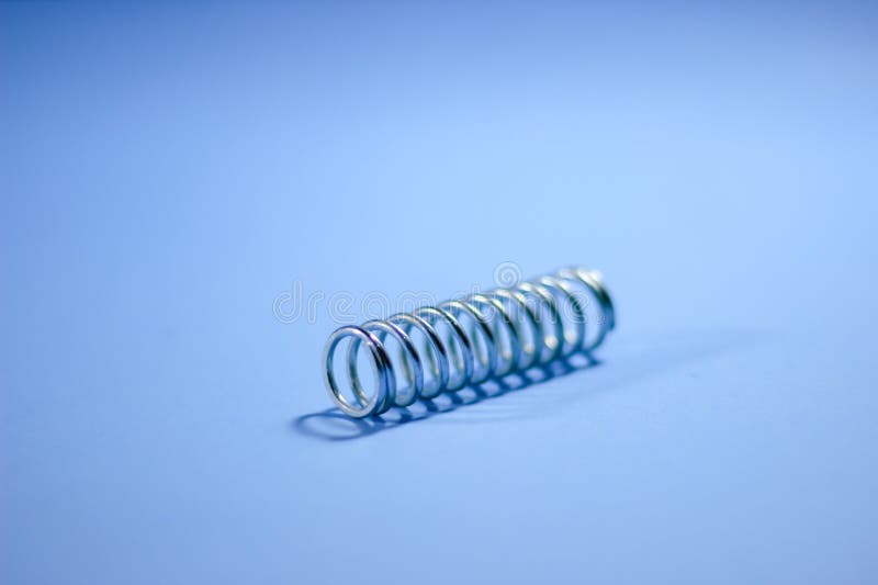 A Spring Made of Metal is Placed on a Blue Table Stock Photo - Image of ...