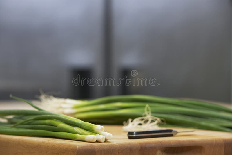 Spring Onions and Knife on Chopping Board Stock Photo - Image of detail ...