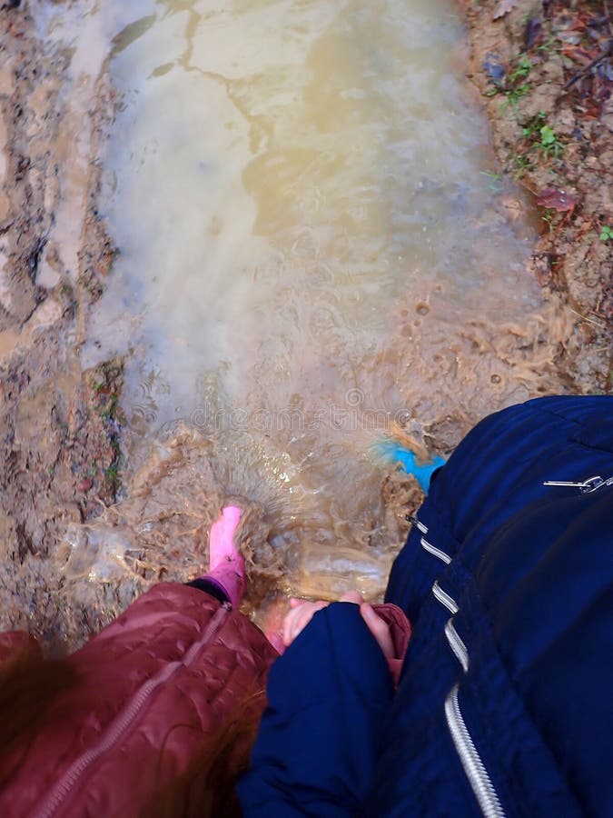 Spring Puddle.puddle Walk. Feets in Blue and Pink Rubber Boots in ...