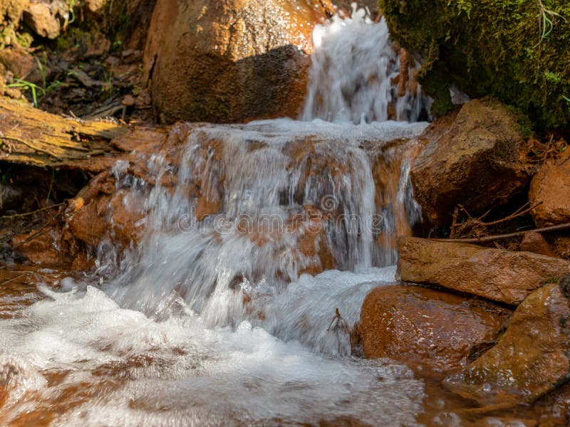 A Spring with a Rapid Rusty Waterfall, Rocks, Green Moss and Spring ...