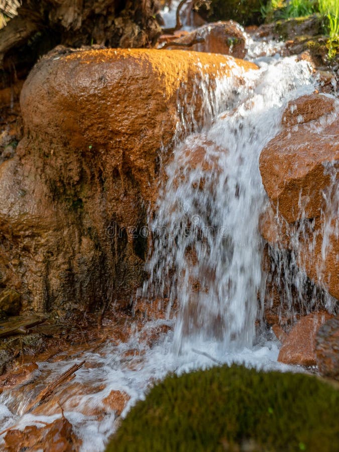 A Spring with a Rapid Rusty Waterfall, Rocks, Green Moss and Spring ...