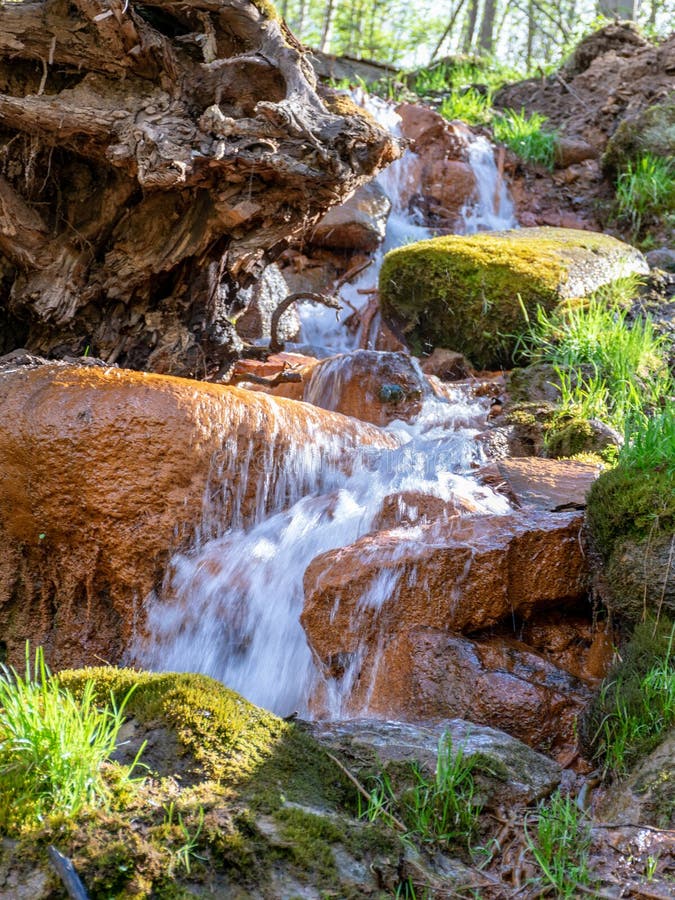 A Spring with a Rapid Rusty Waterfall, Rocks, Green Moss and Spring ...