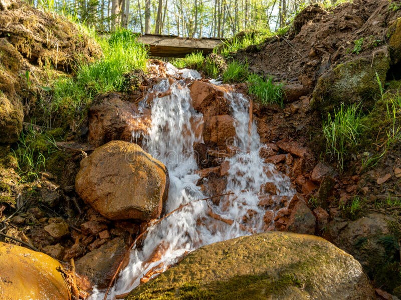 A Spring with a Rapid Rusty Waterfall, Rocks, Green Moss and Spring ...