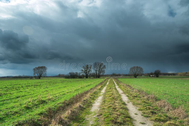 Spring Storm Clouds and a Dirt Road through Green Fields Stock Photo ...