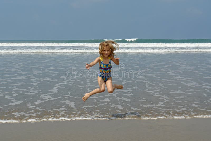 Springendes Kind Auf Dem Strand Stockfoto - Bild von freiheit, luft ...