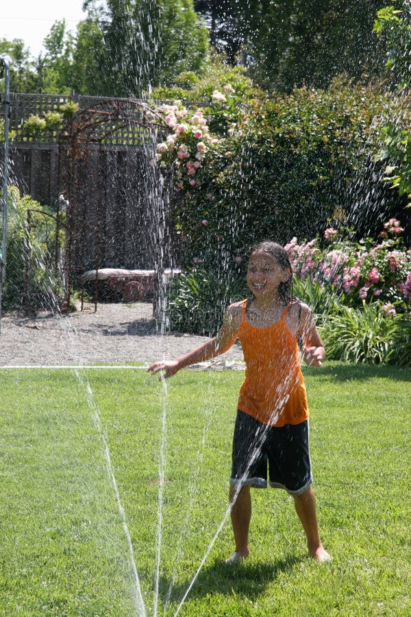 Boy playing in sprinklers. stock image. Image of water - 7337787