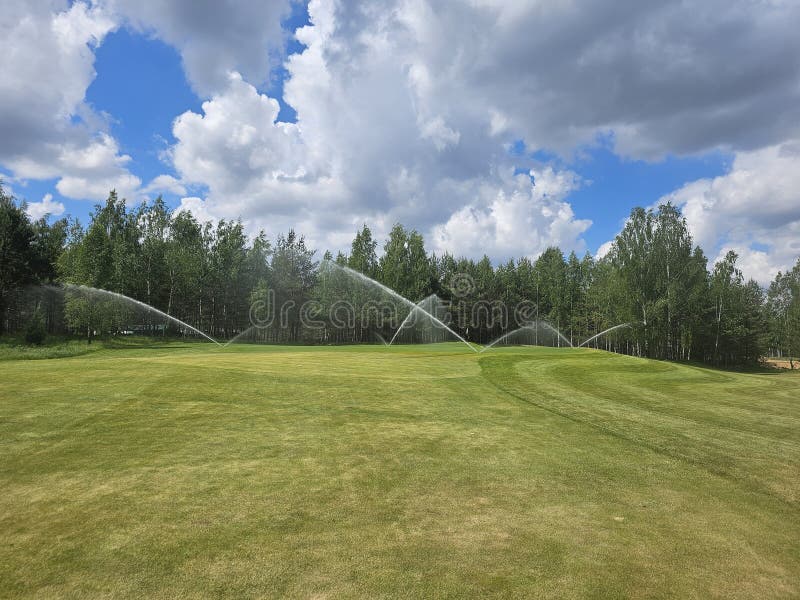 Sprinkler System for Watering a Golf Course on a Sunny Day Stock Photo ...