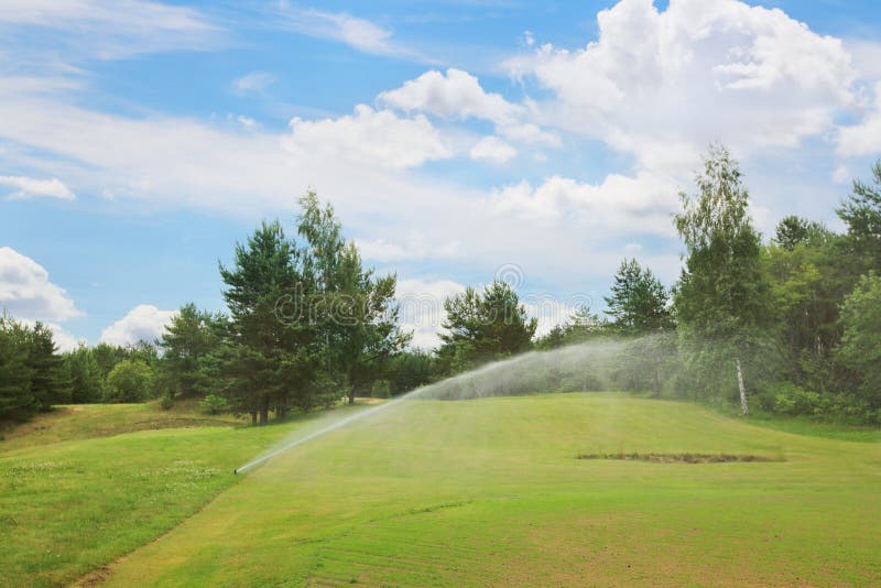Sprinklers at golf course stock photo. Image of growth - 73767986