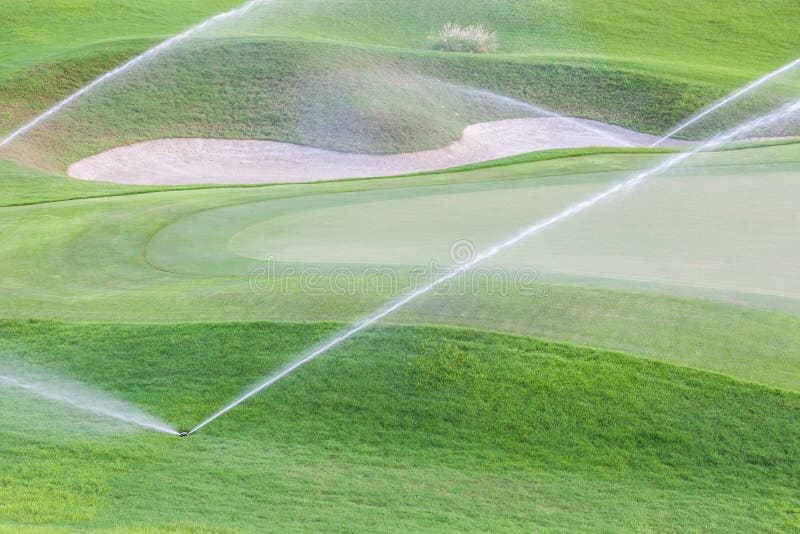 Sprinklers Watering System Working in Green Golf Course. Stock Photo ...