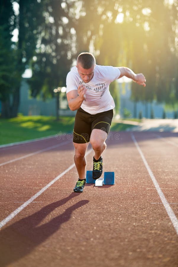 Sprinter Leaving Starting Blocks on the Running Track. Explosive Start ...