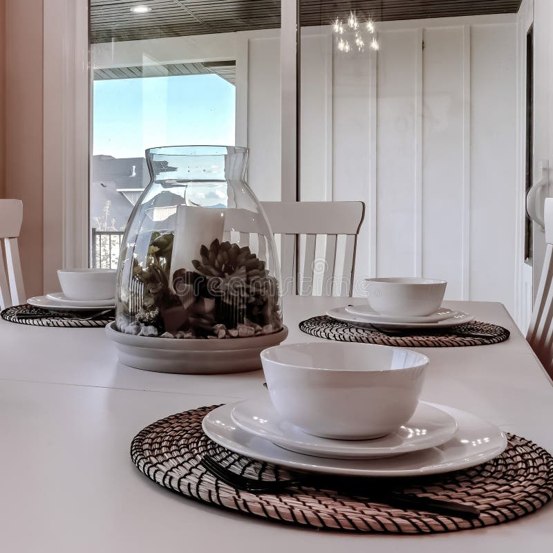 Square Dining Table with Chairs and Tableware Arranged Around a ...