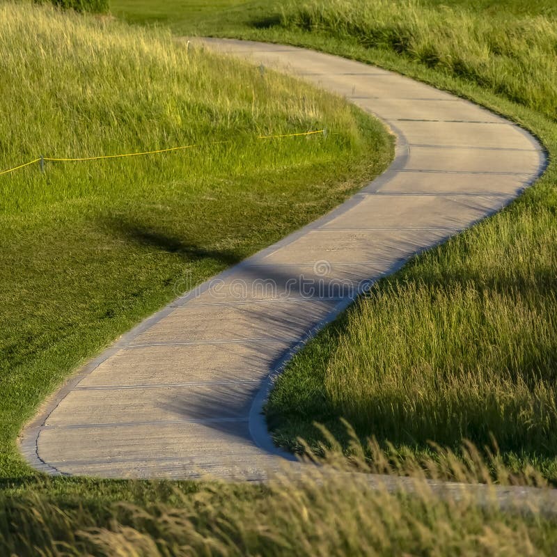 Square Frame Pathway that Winds through a Grassy Terrain with Houses in ...