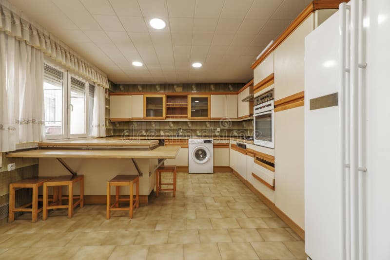 A Square Kitchen with Cabinets Along Two Walls and a Large Island Stock ...