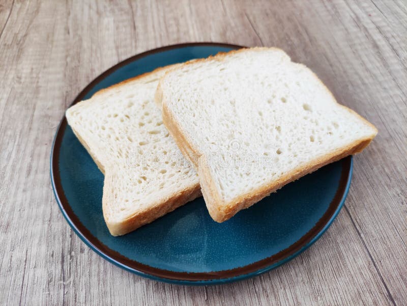 Square Pieces of White Toast Bread on a Blue Plate on Wooden Background ...