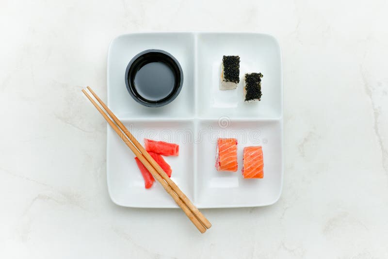 Square Plate with Rolls and Sushi on a White Table. Soy Sauce an Stock ...