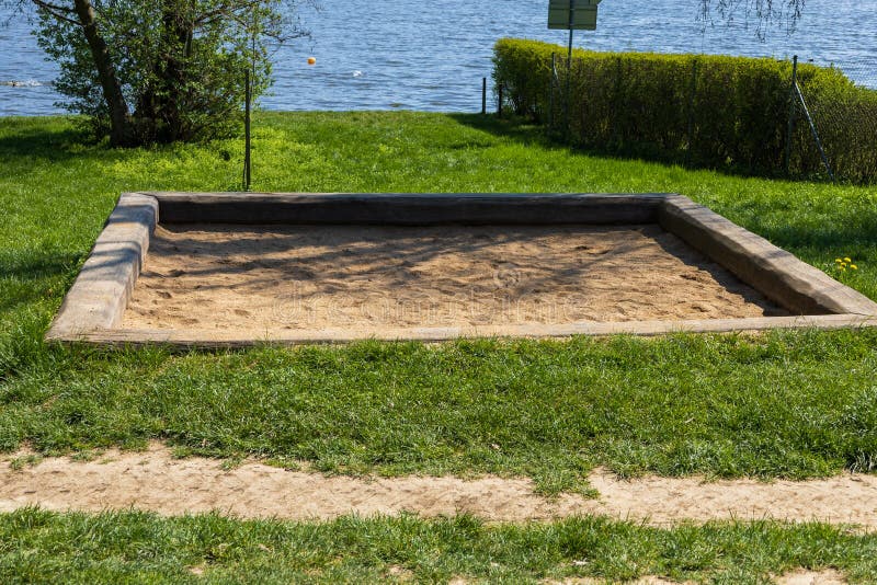 A Square Sandpit for Children in a Meadow by the Water Stock Image ...