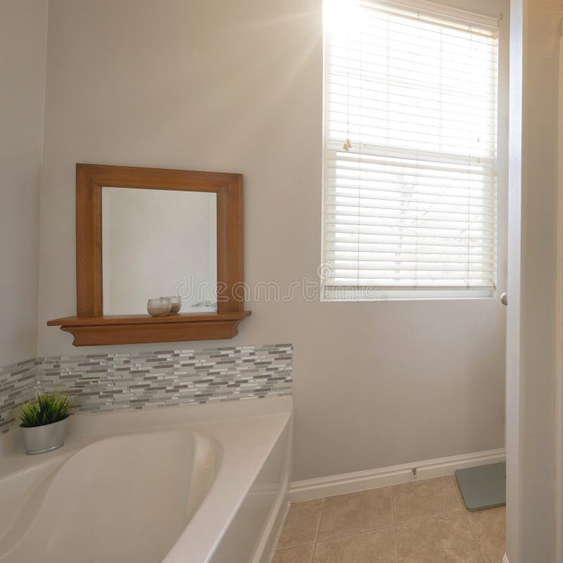 Square Sun Flare Interior of a Bathroom with Window and Framed Mirror ...