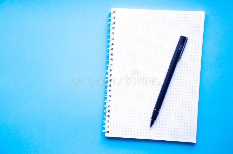 Squared Notebook on a Blue Background. Black Pen and Notebook and ...