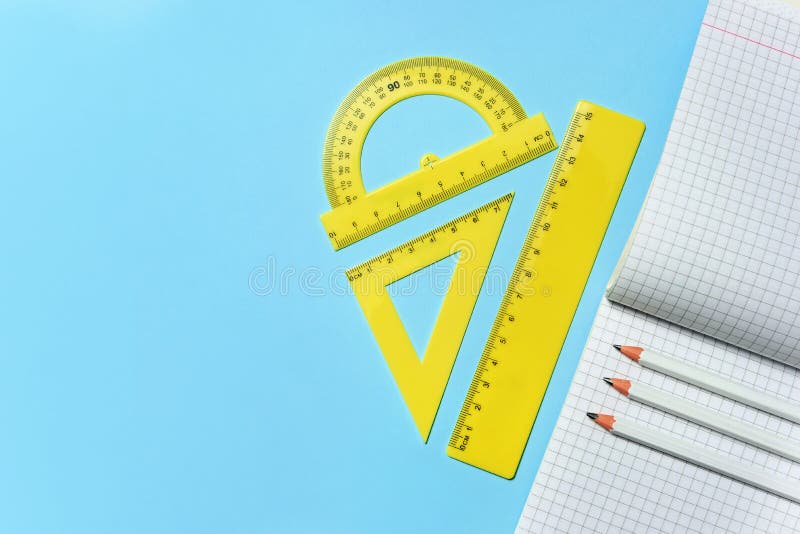 Squared School Notebook, Pencils and Set of Rulers on a Blue Background ...