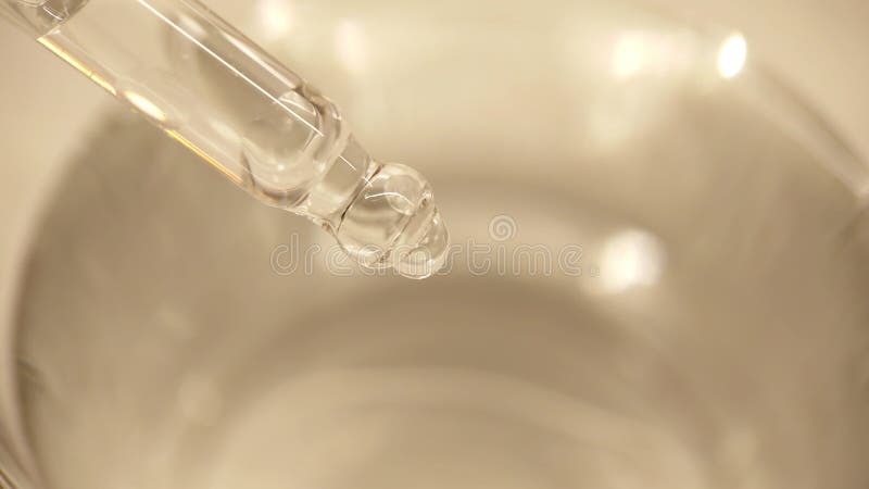 Squeeze a Drop of Light Liquid from a Pipette into Water Stock Footage ...
