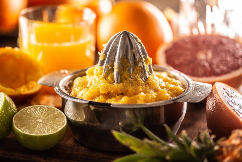 Squeezed Orange Pulp in a Juicer with Cfreshly Cut Citruses and a Glass ...