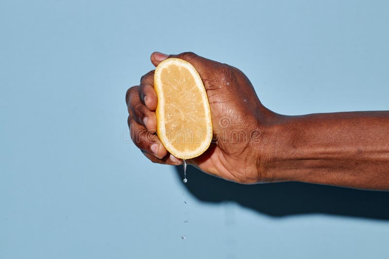 Squeezing Fresh Lemon in Hand with Blue Background Stock Photo - Image ...