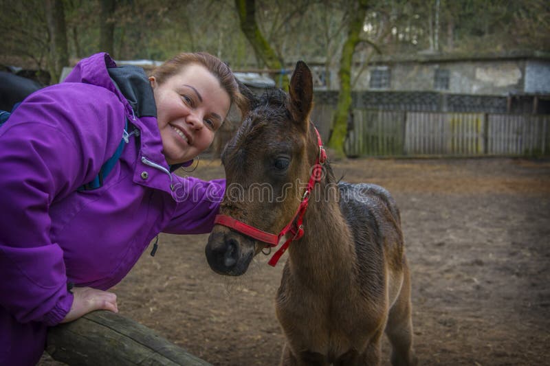 At the Stable, a Happy Girl Hugs a Foal Stock Image - Image of helmet ...
