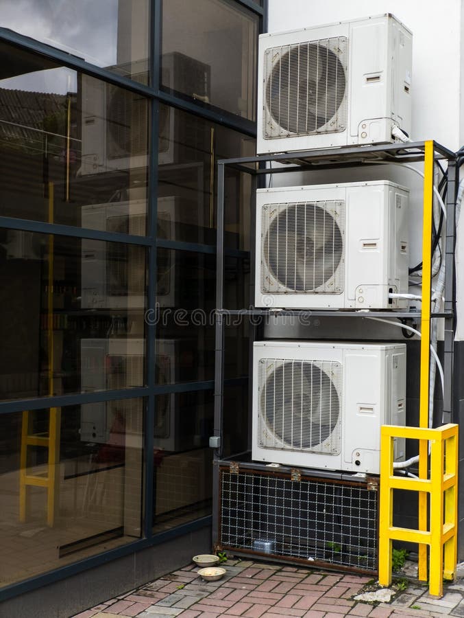 A Stack of Air Conditioners Sitting on Top of Each Other in Front of a ...