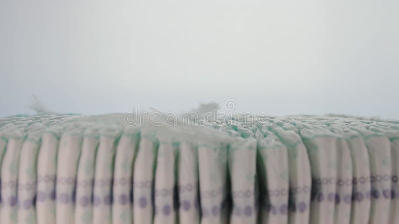 Stack of Baby Diapers with Light Feathers on a White Background ...