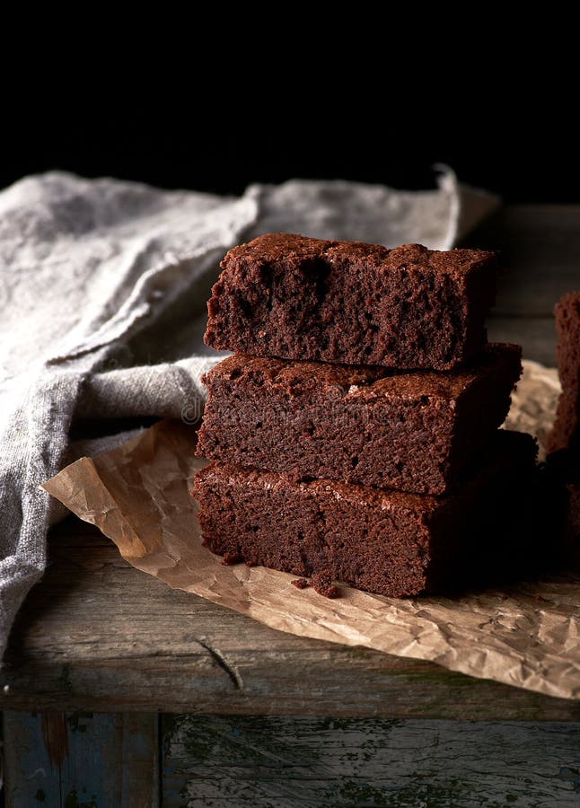 A Stack of Baked Square Pieces of Chocolate Brownie Cake on Brown ...