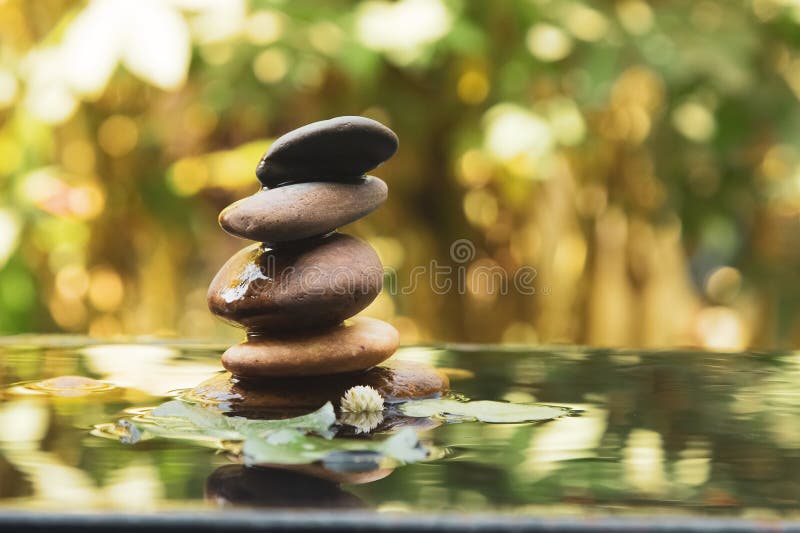 Stack of Balanced Rocks Pyramid on Water with Golden Light Natural ...