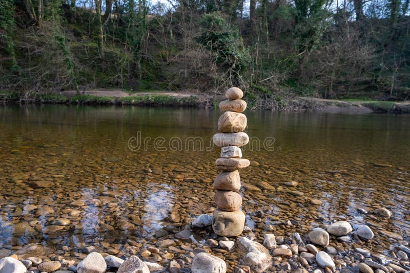 A Stack of Balancing Stones Creating Rock Art Next To Water Stock Photo ...