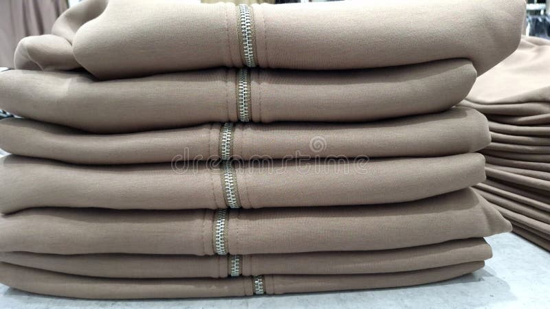 Stack of Beige Folded Clothes with Zippers on Display Stock Photo ...