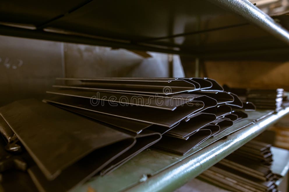 A Stack of Bent Metal Sheets is Organized on a Shelf within a Workshop ...