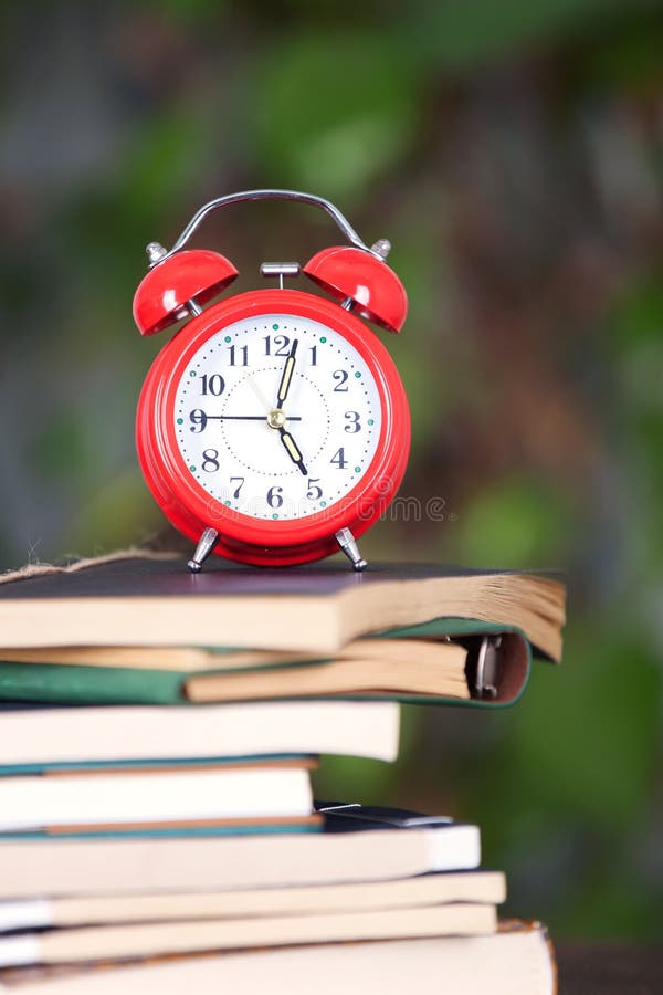 A Stack of Books and an Alarm Clock on it Stock Photo - Image of ...