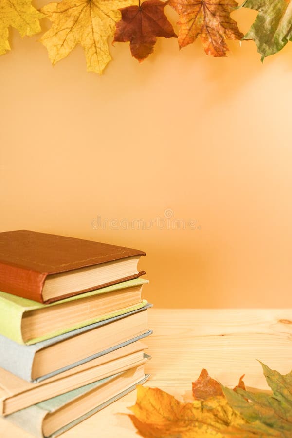 Stack of Books and Autumn Maple Leaves are Lying on Wooden Table on ...