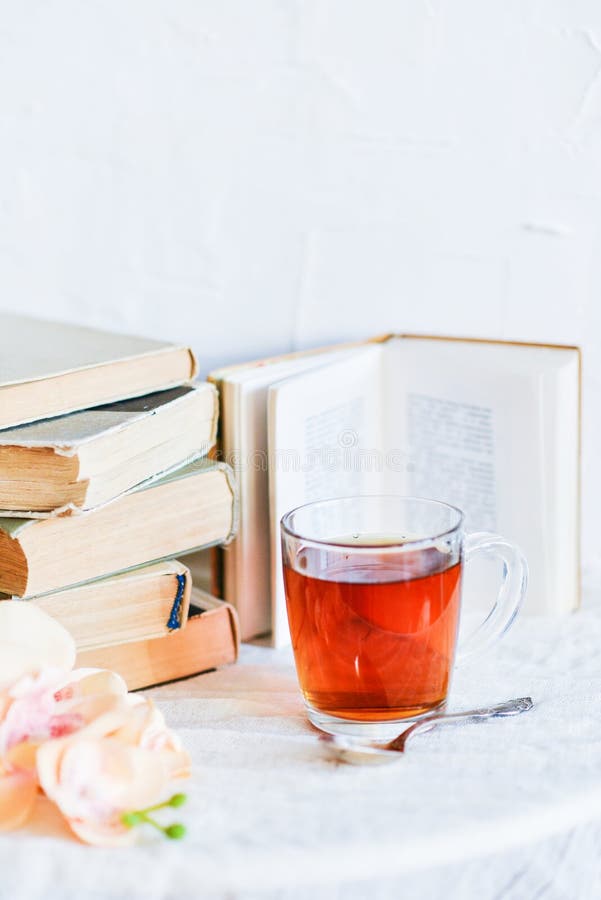 A Stack of Books, a Book and Tea in a Glass Cup on Bright Background ...