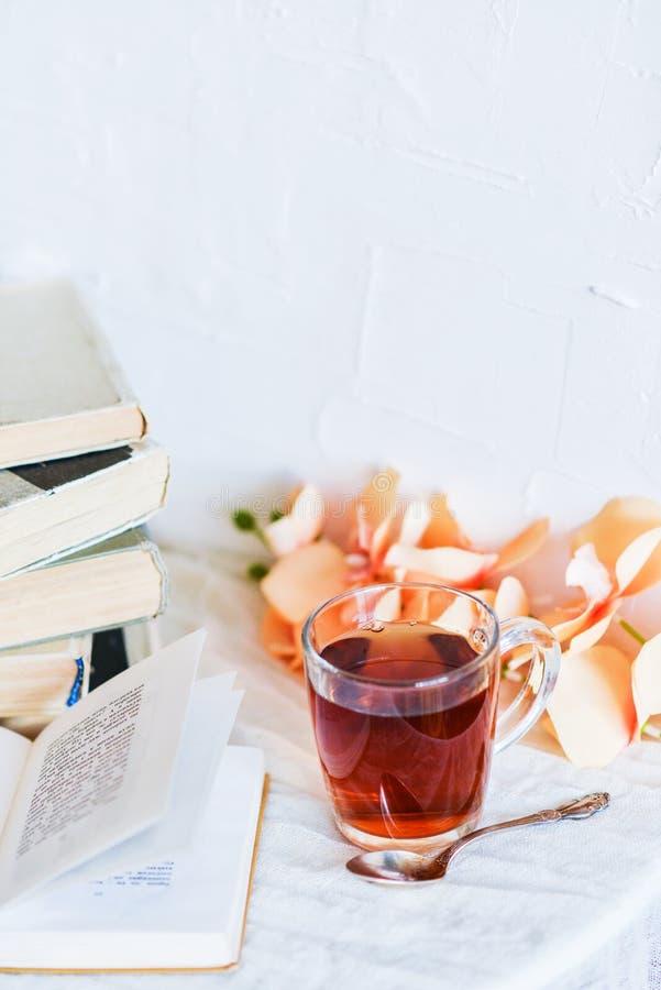 A Stack of Books, a Book and Tea in a Glass Cup on Bright Background ...