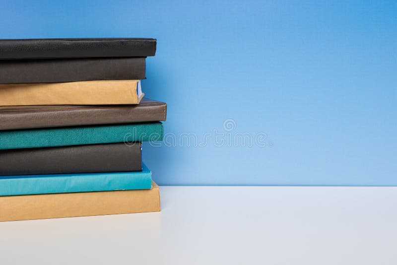 Stack of Books in the Colored Cover Lay on the Wooden Table and Blue ...