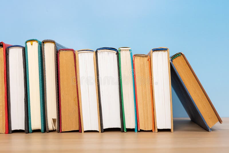 Stack of Books in the Colored Cover Lay on the Wooden Table and Blue ...