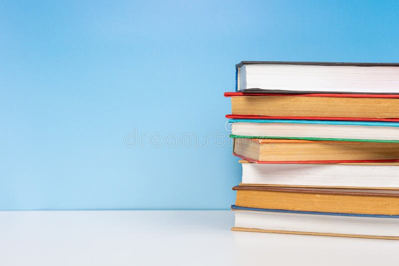Stack of Books in the Colored Cover Lay on the Wooden Table and Blue ...