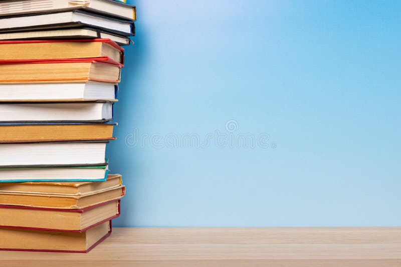 Stack of Books in the Colored Cover Lay on the Wooden Table and Blue ...