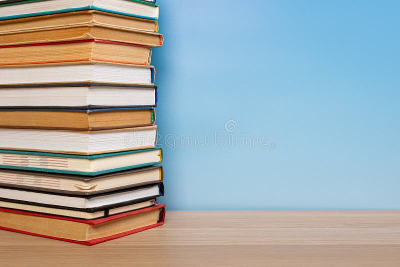 Stack of Books in the Colored Cover Lay on the Wooden Table and Blue ...