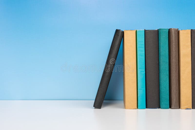 Stack of Books in the Colored Cover Lay on the Wooden Table and Blue ...