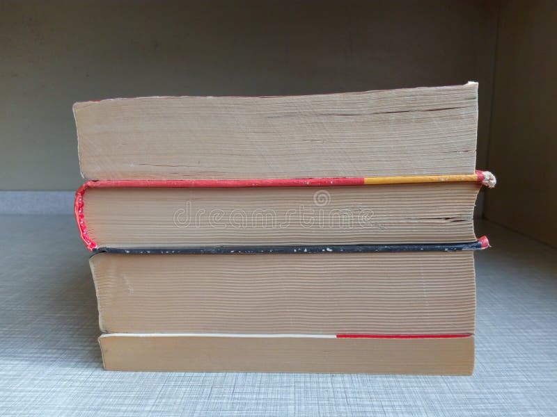 A Stack of Books on a Gray Table Side View of the Bottom of the Books ...